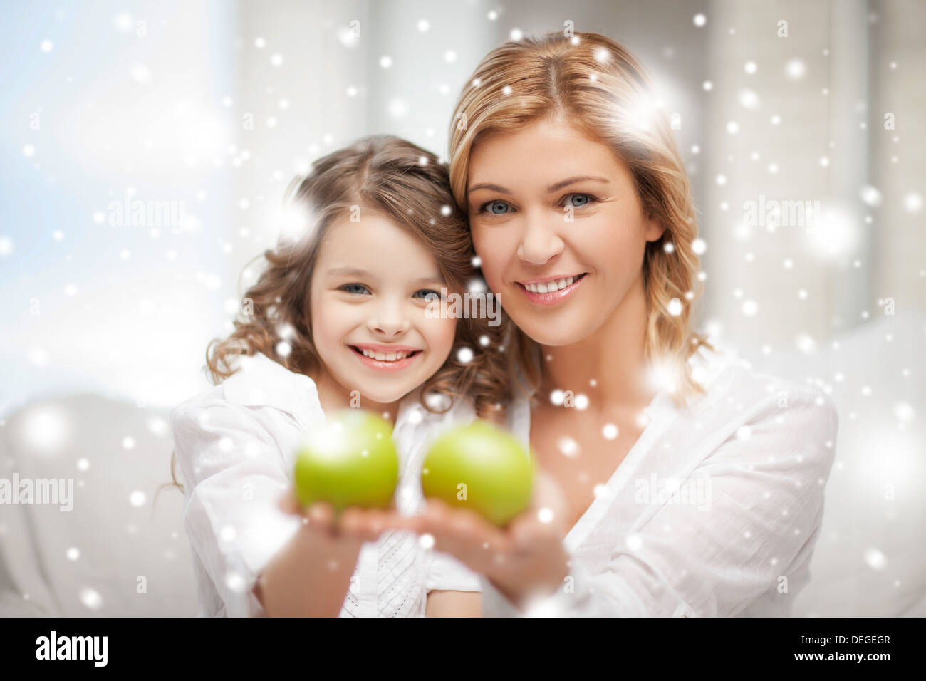 mother and daughter holding green apples Stock Photo - Alamy