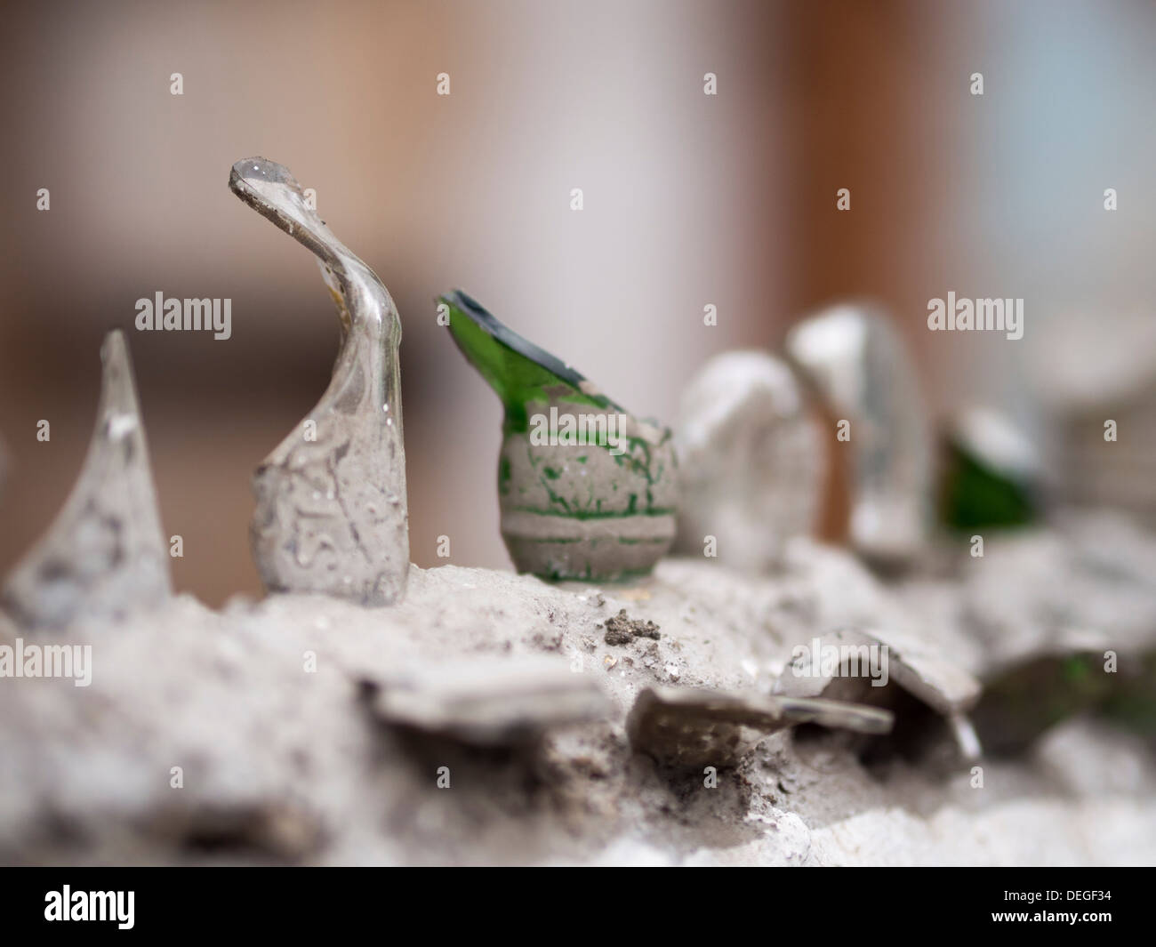 Shards of glass beer bottles stick out at the top of a concrete wall in ...