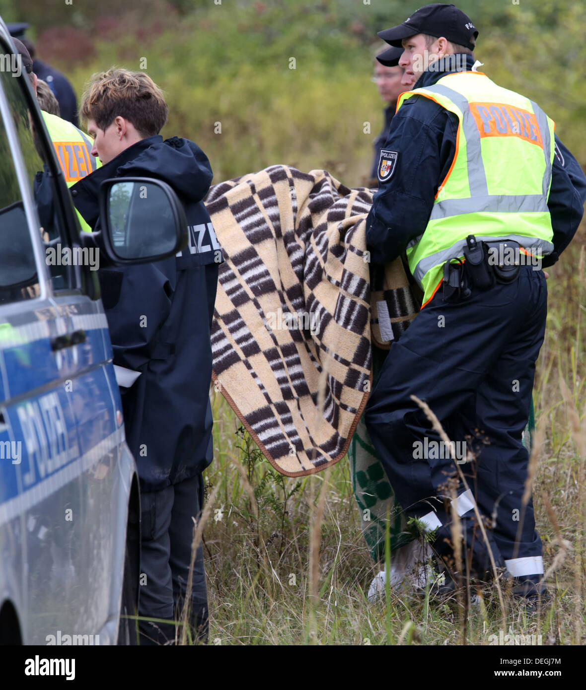 Police officers bring a 37-year-old prisoner covered with blankets that ...