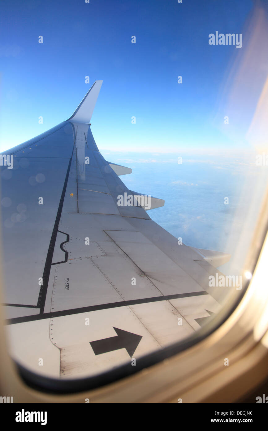 Airplane in the blue sky engine and wings white clouds Stock Photo - Alamy