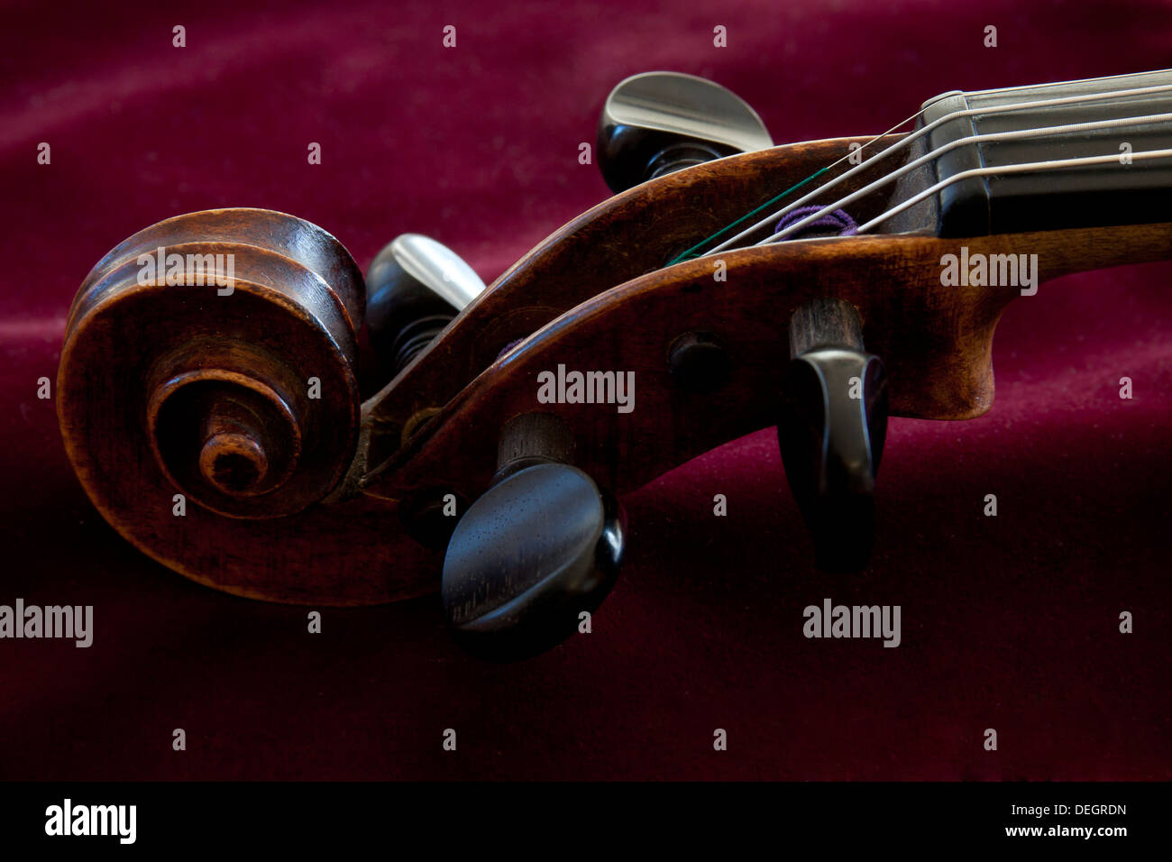 A low key image of a violin scroll resting on burgundy velvet Stock ...