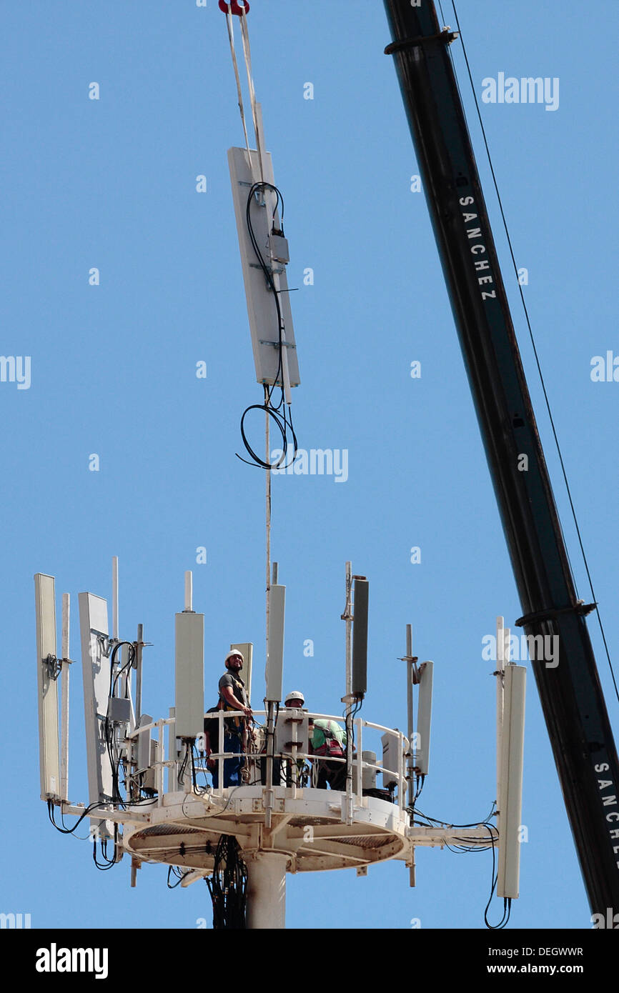 Workmen installing a new mobile phone cell tower array Stock Photo - Alamy