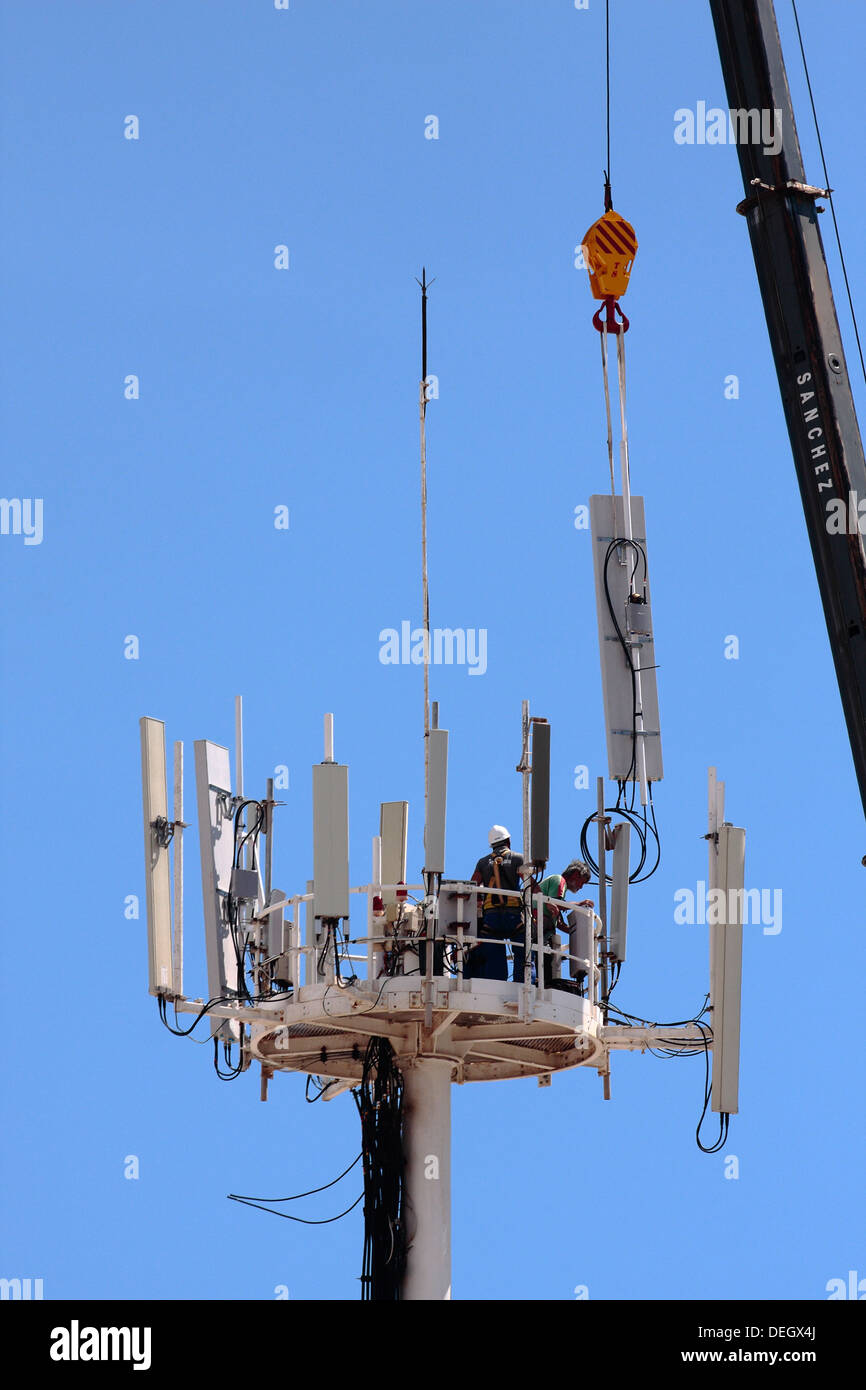 Workmen installing a new mobile phone cell tower array Stock Photo - Alamy