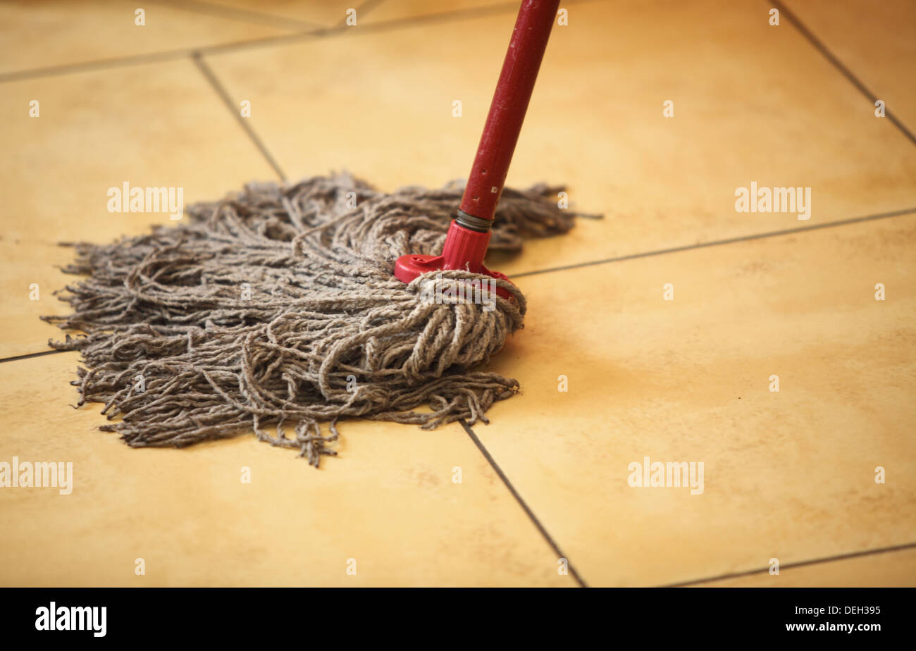 cleaning the floor with a old mop, mopping Stock Photo - Alamy