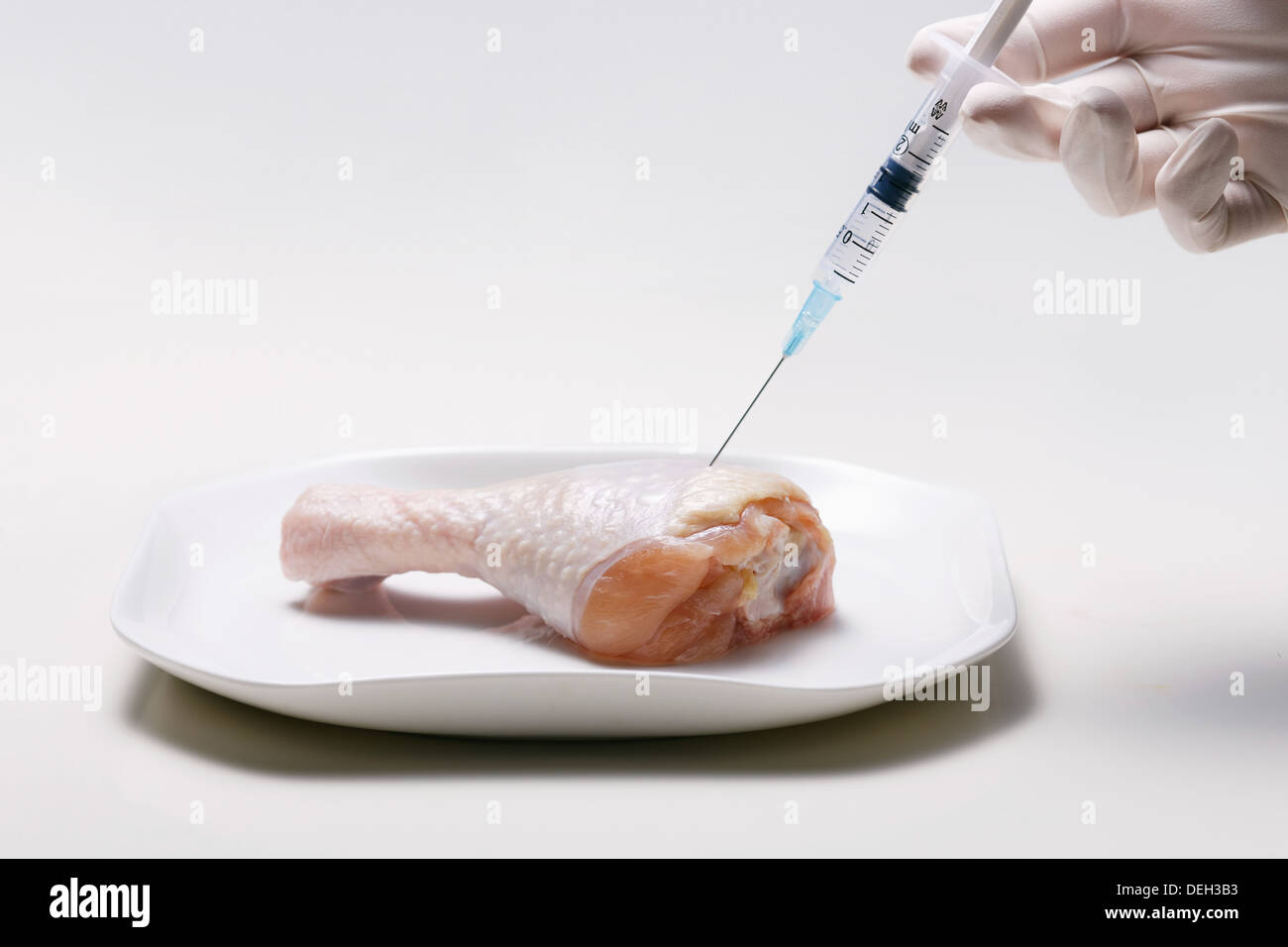 Scientist giving chicken leg an injection by syringe Stock Photo - Alamy