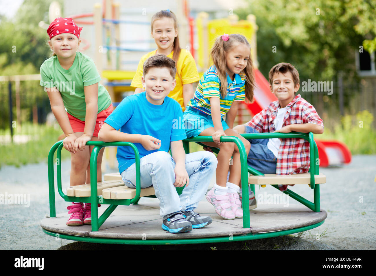 Image of cute friends having fun on carousel outdoors Stock Photo - Alamy