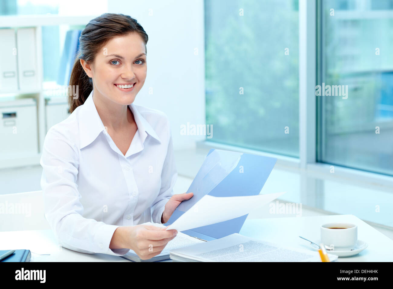 Portrait of happy employer holding test results and looking at camera ...
