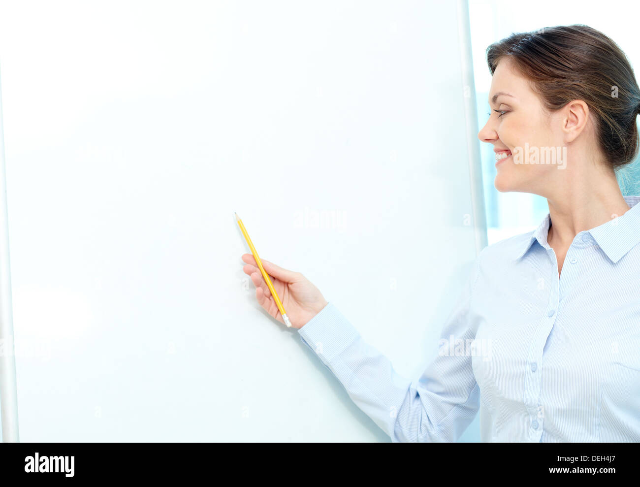 Portrait of a smiling teacher pointing at a blank whiteboard Stock ...