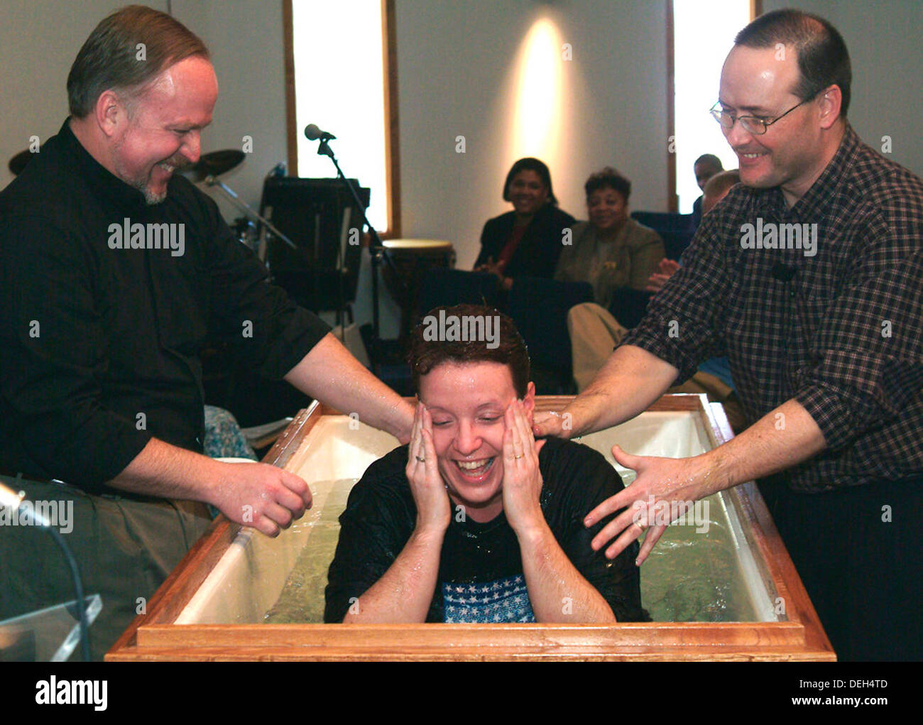 Woman reacts joyfully after being baptized in a church service in ...