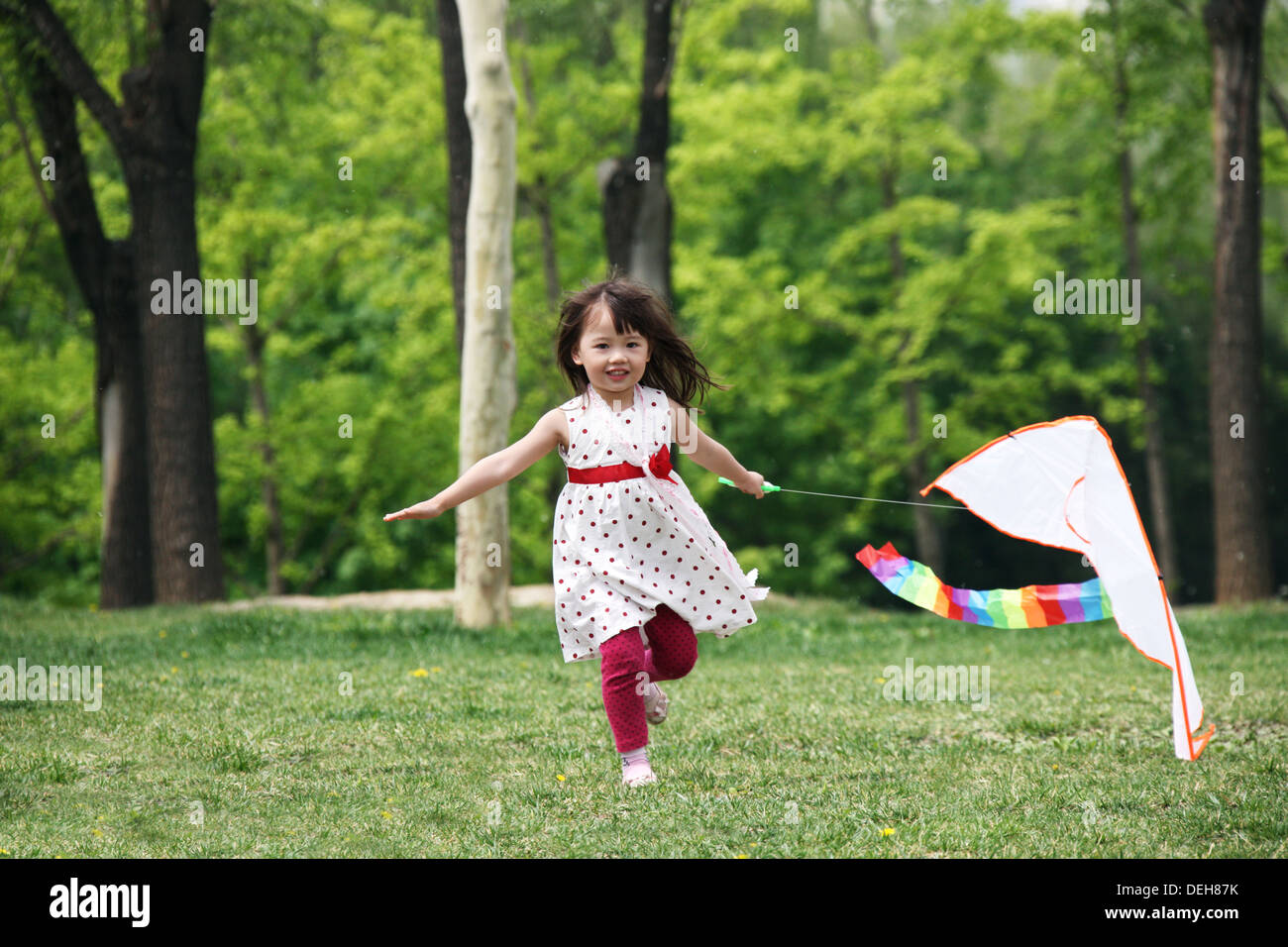 A girl playing kite outside Stock Photo - Alamy