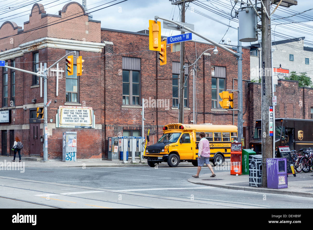 Yellow school bus stops at traffic lights on the corner of Queen street ...
