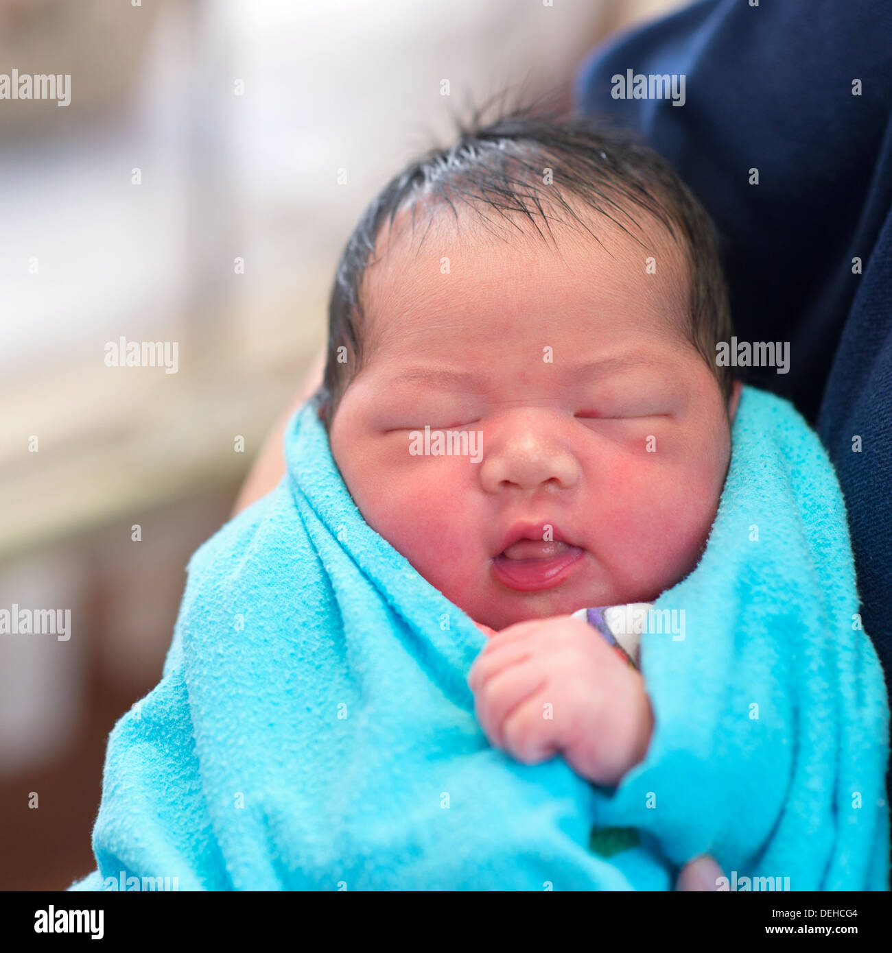 Newborn Asian baby girl smiling and fall asleep in father's arms ...
