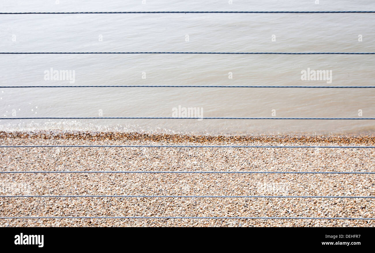 River Thames Shingle beach behind wire rope fence Stock Photo - Alamy