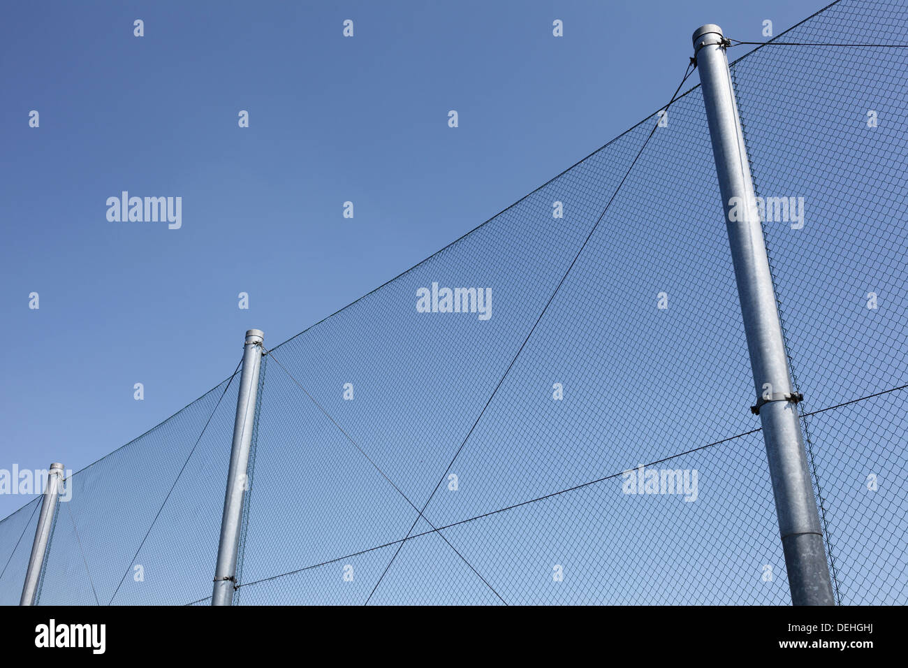 metal wire fence with blue sky in background Stock Photo - Alamy
