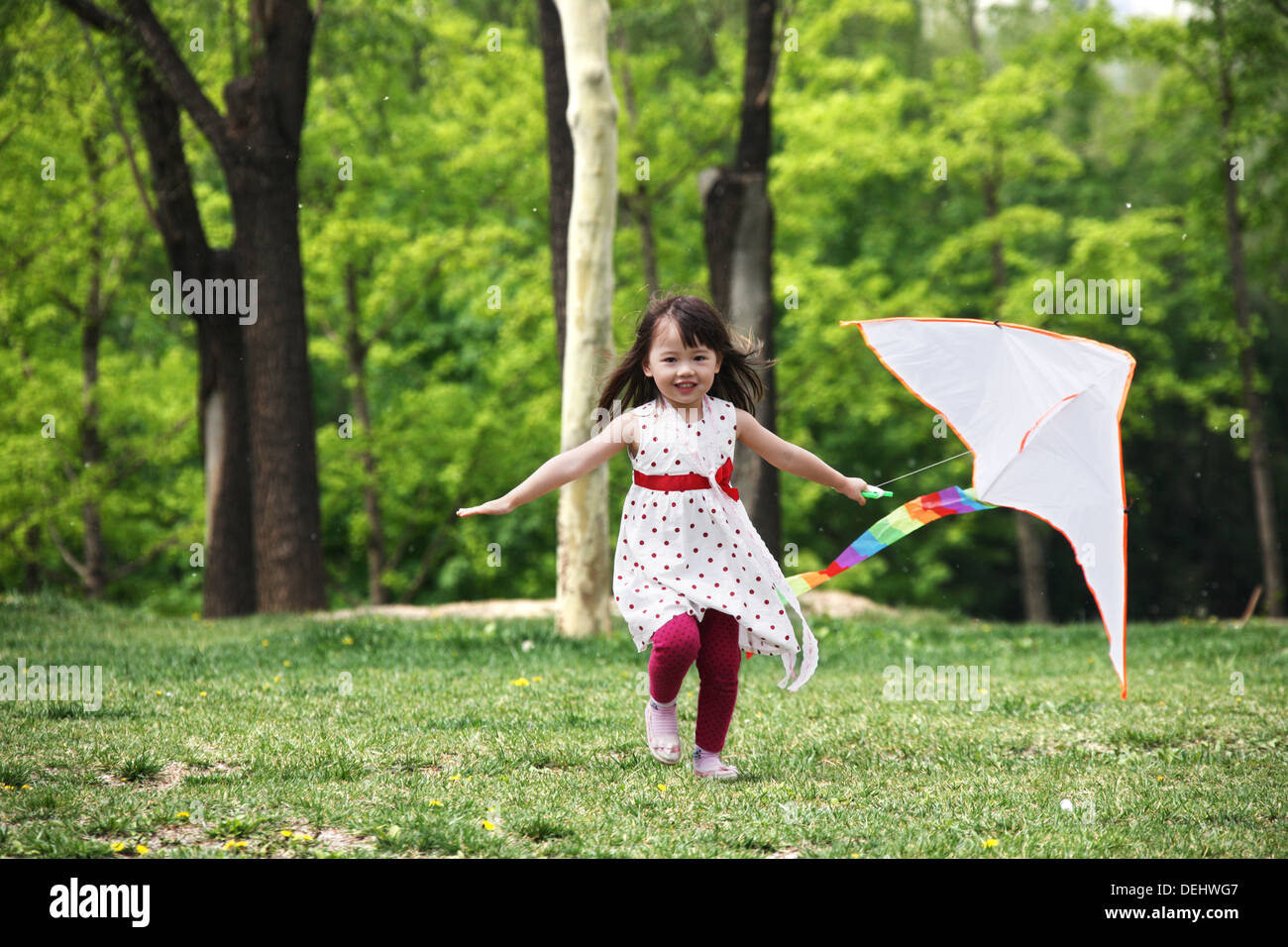 A girl playing kite outside Stock Photo - Alamy