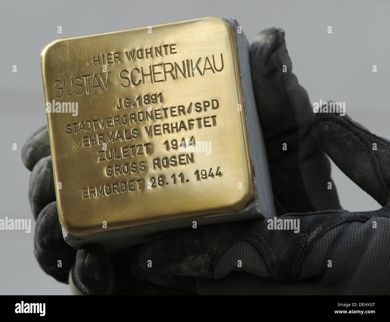 The artist Gunter Demnig holds up the 'Stolperstein' for Gustav ...