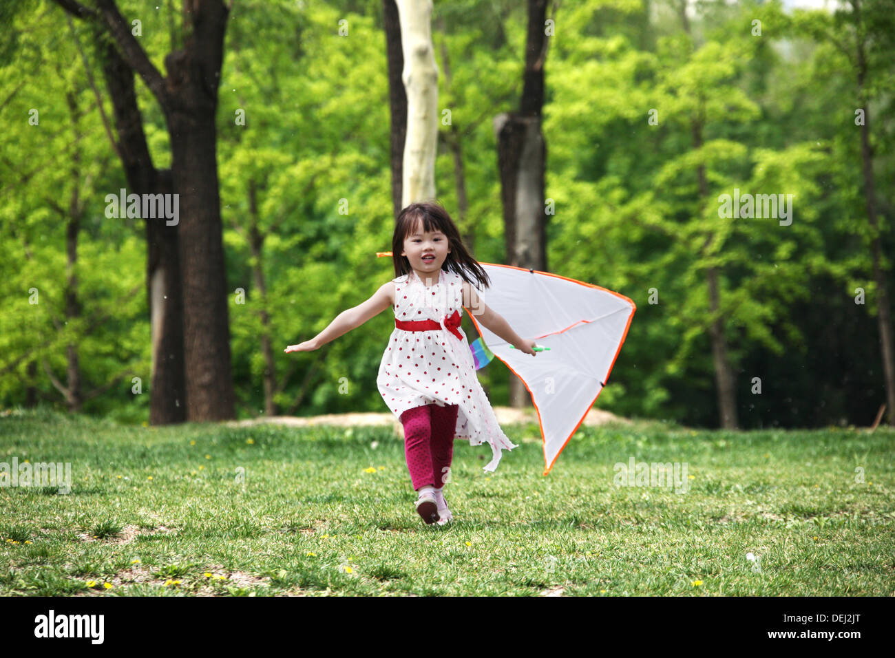 A girl playing kite outside Stock Photo - Alamy