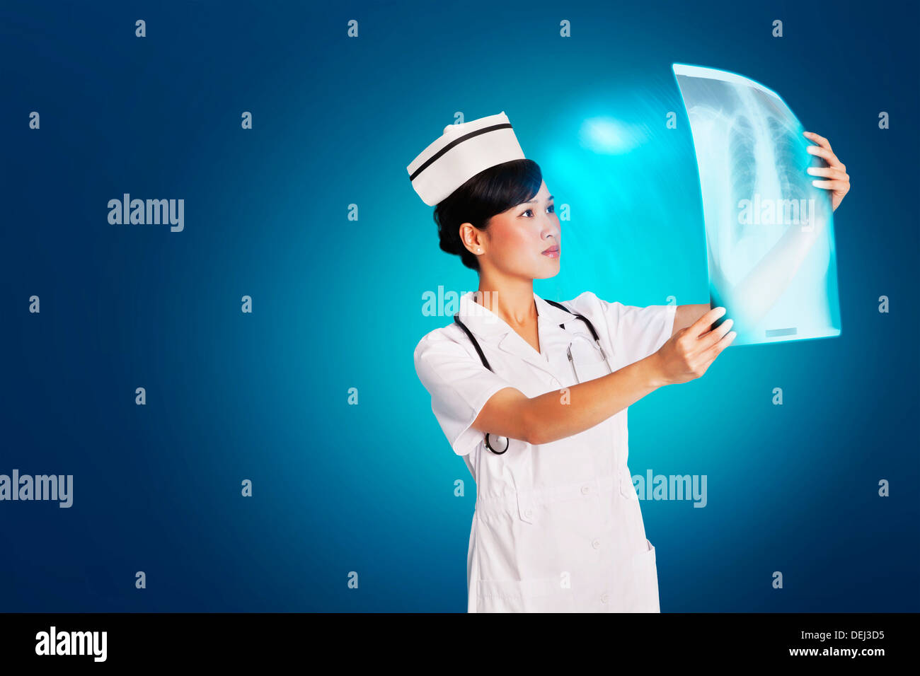 Female doctor analyzing x-ray report over blue background Stock Photo ...