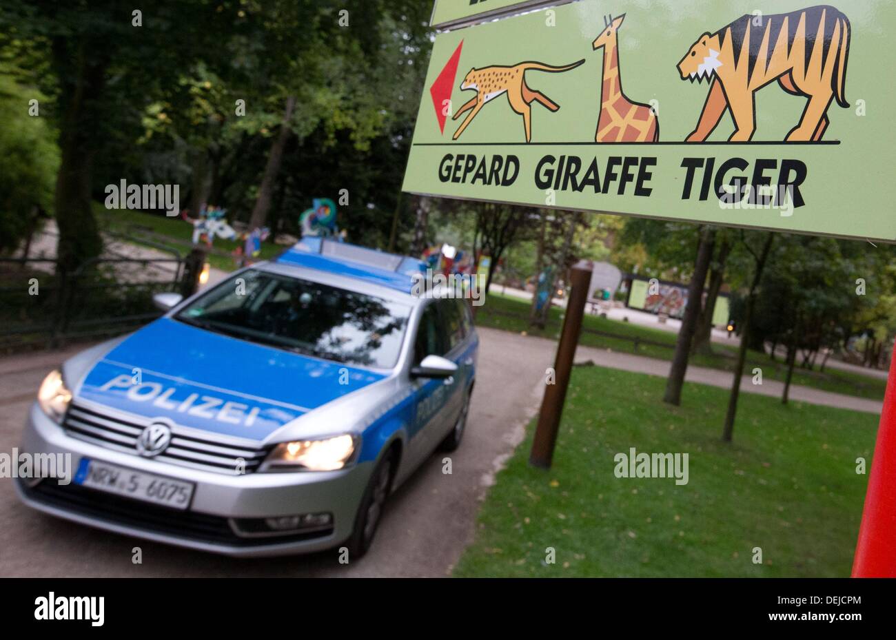 A police car stands behind a signpost at the zoo 'Allwetterzoo Münster ...