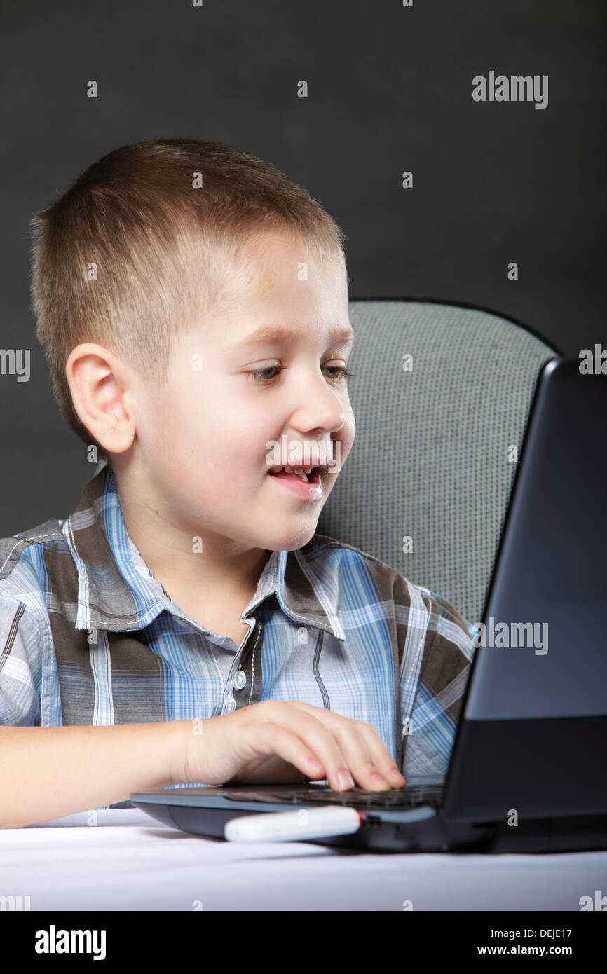 Little kid boy playing on the computer laptop. Technology Stock Photo ...