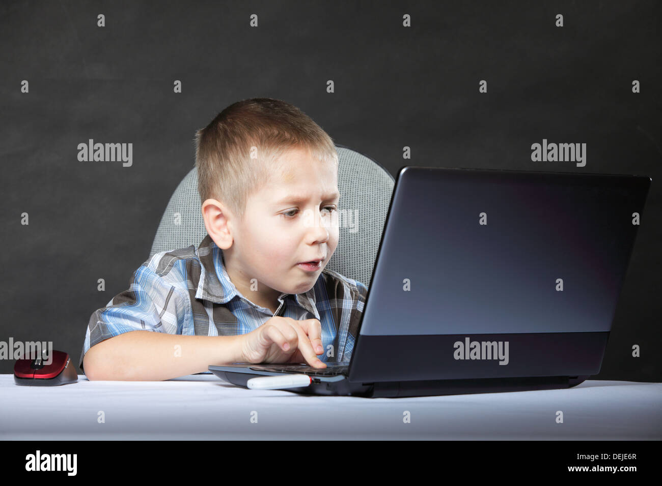 Little kid boy playing on the computer laptop. Technology Stock Photo ...