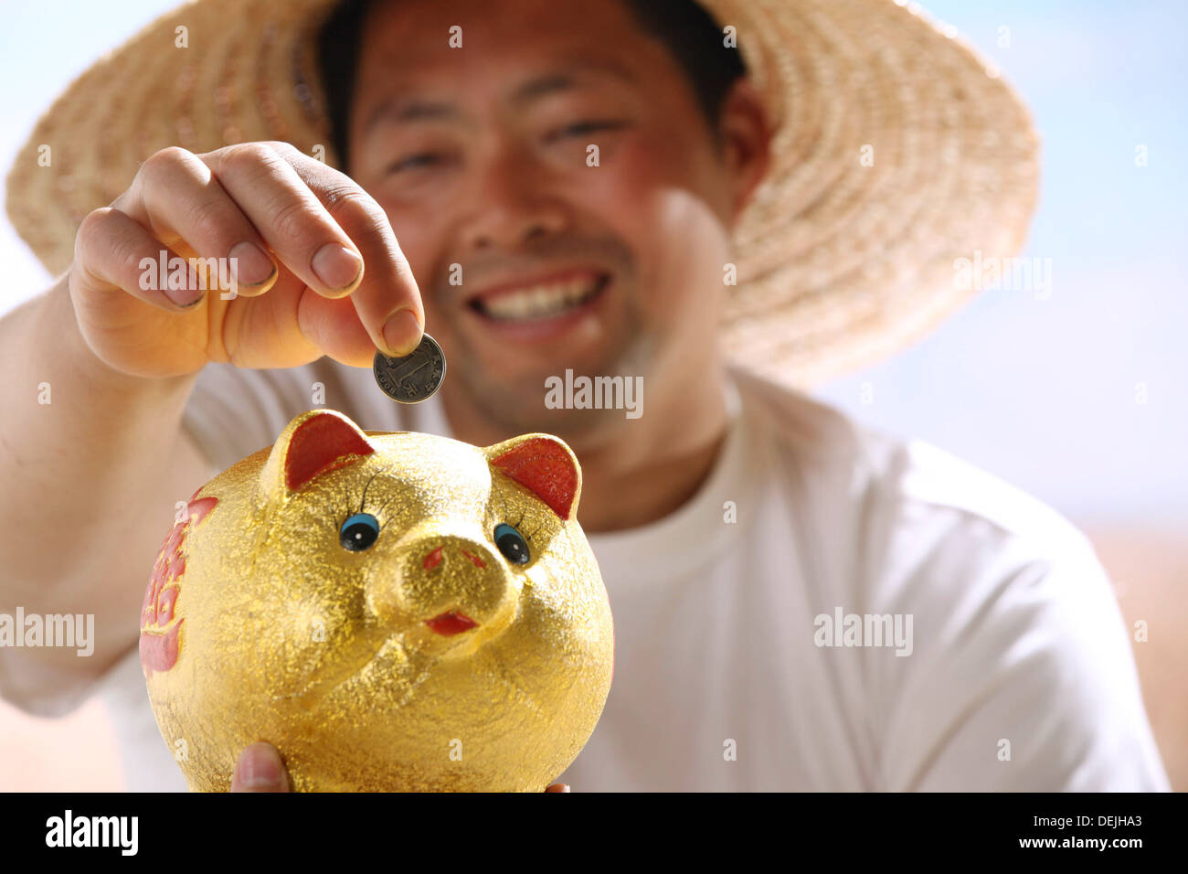 Farmer putting coin in piggy bank Stock Photo - Alamy