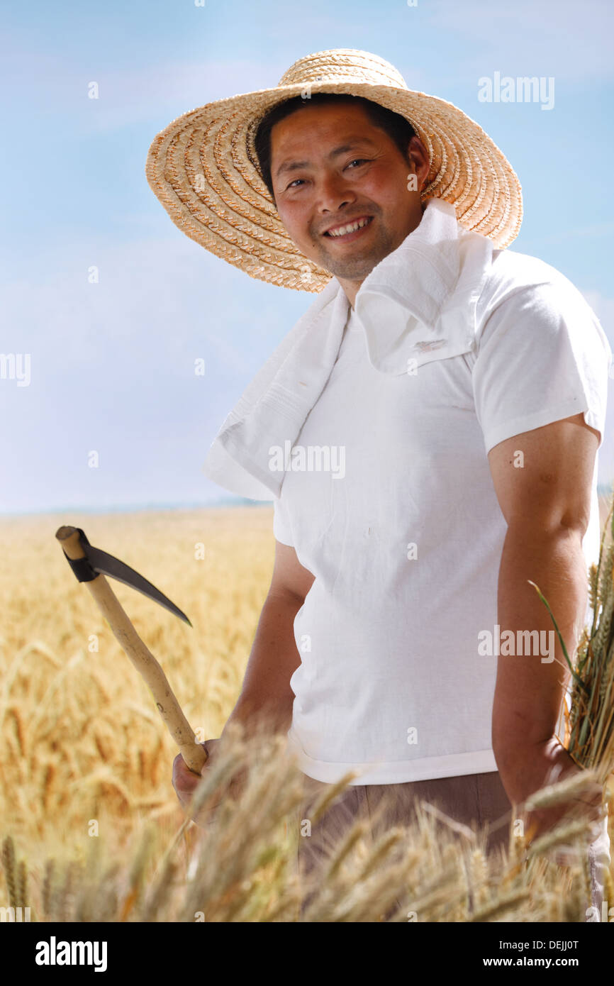 Farmer holding sickle in wheat field Stock Photo - Alamy