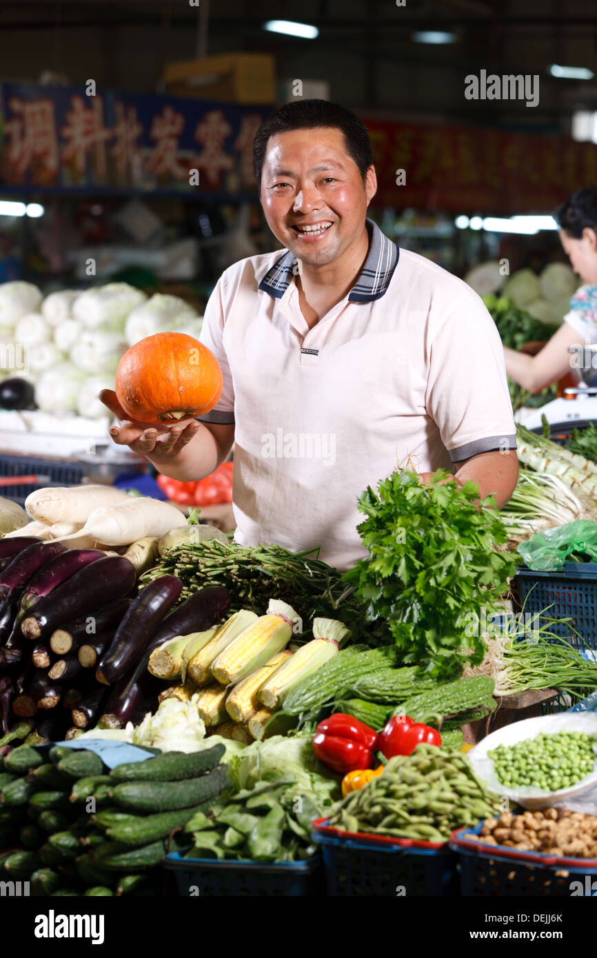 Farmer selling vegetables in food market Stock Photo - Alamy