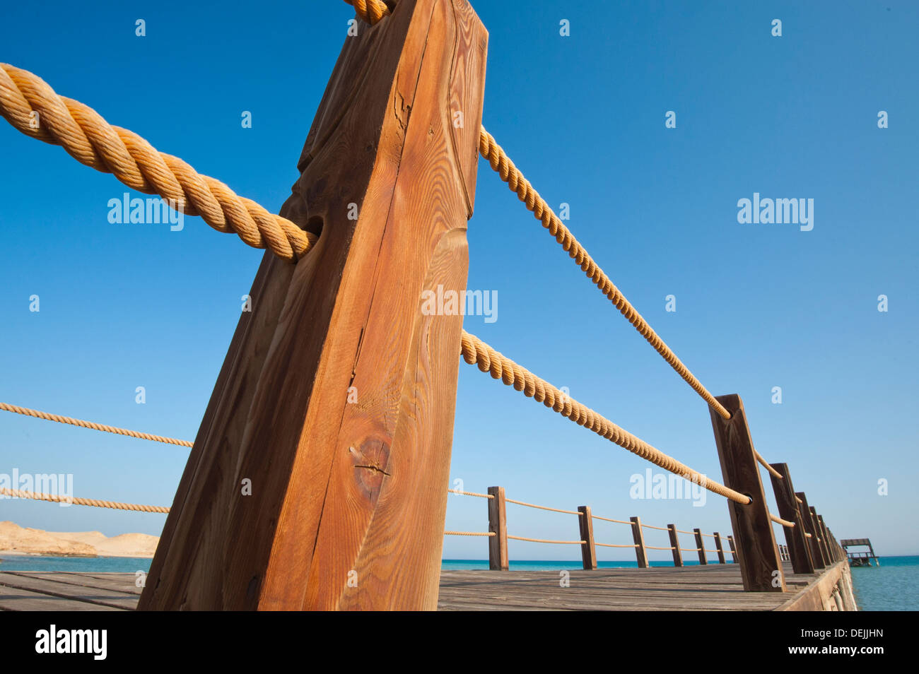 Long wooden jetty on a tropical island stretching out into the sea ...
