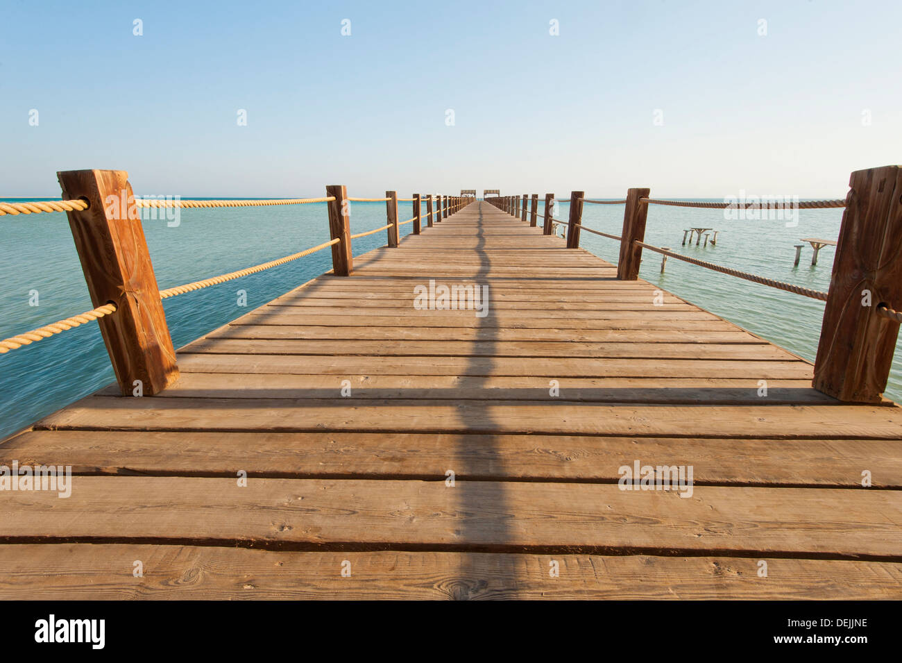 Long wooden jetty on a tropical island stretching out into the sea ...