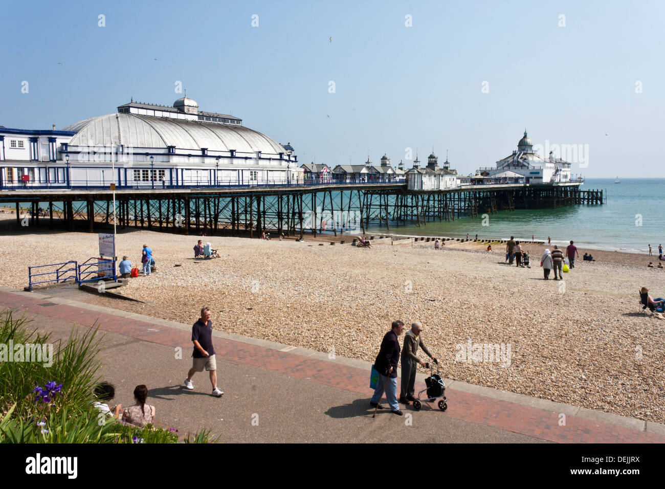 Visitors enjoy the spring sunshine on the beach. The pier at Eastbourne ...