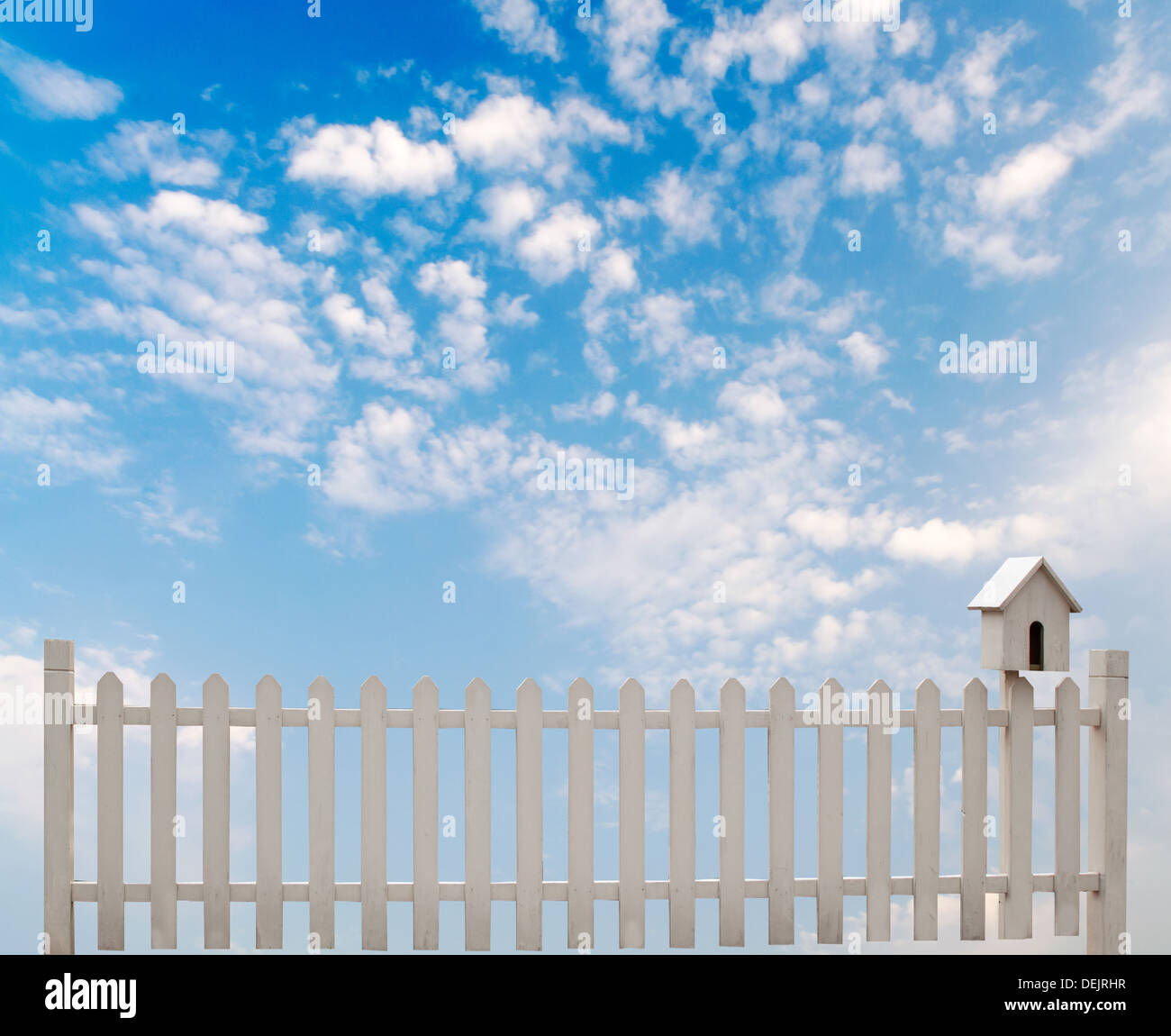 white fence with bird house and blue sky Stock Photo - Alamy