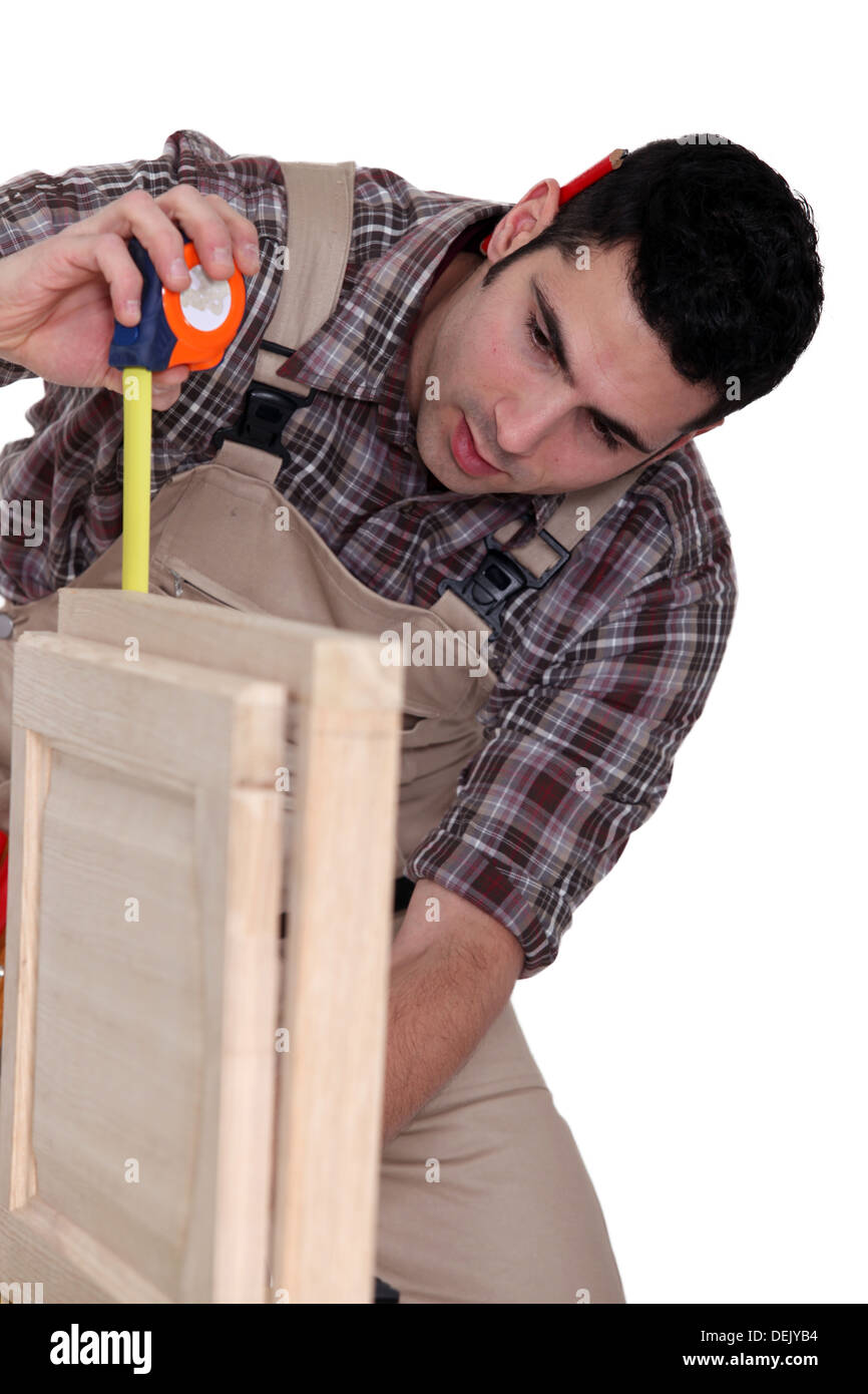 Carpenter measuring a piece of furniture Stock Photo - Alamy