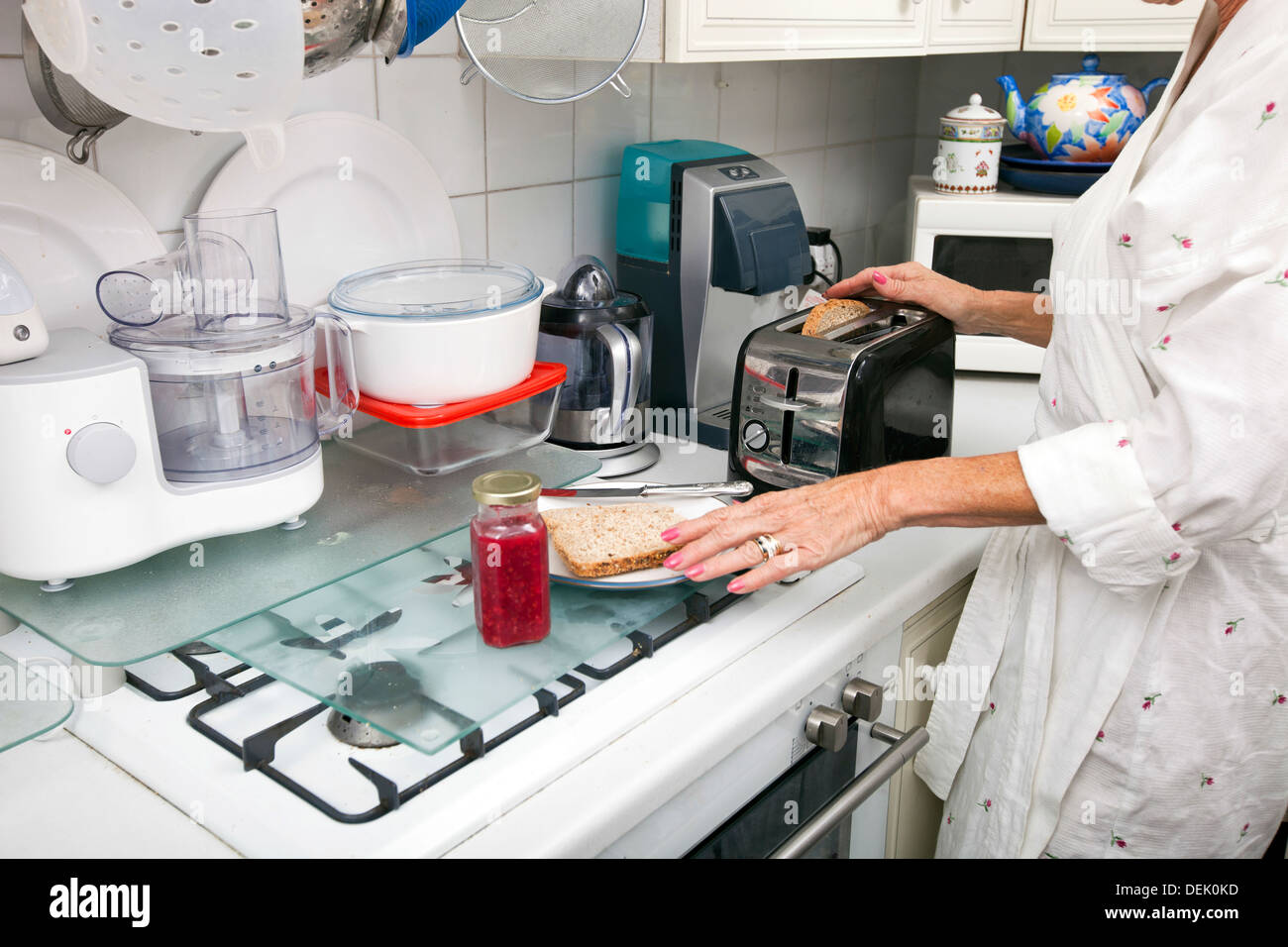Midsection of senior woman preparing toast at kitchen counter Stock ...