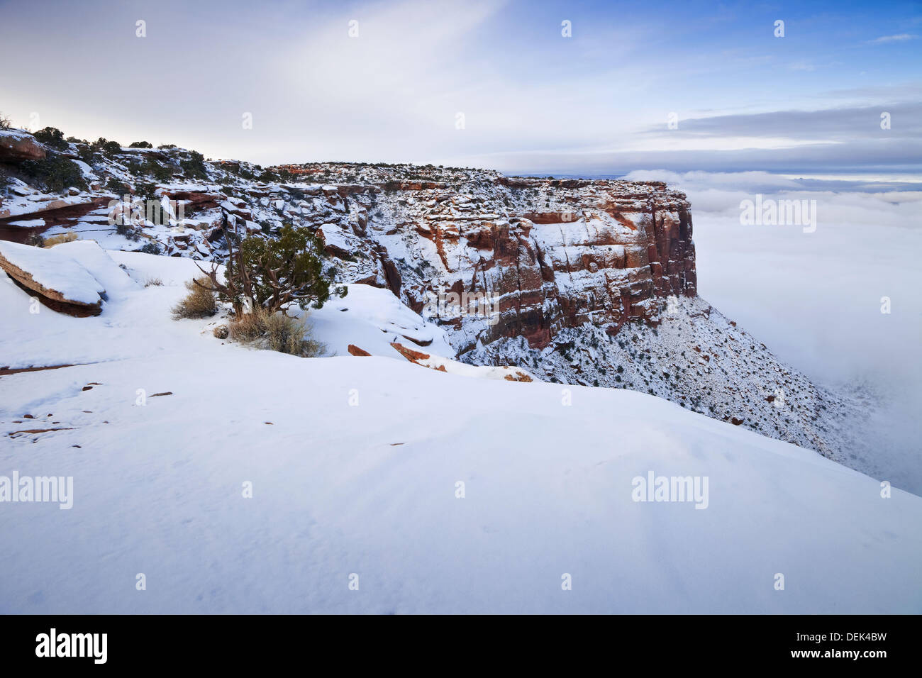 Red rock canyons are covered in a layer of snow as fog rolls in below ...