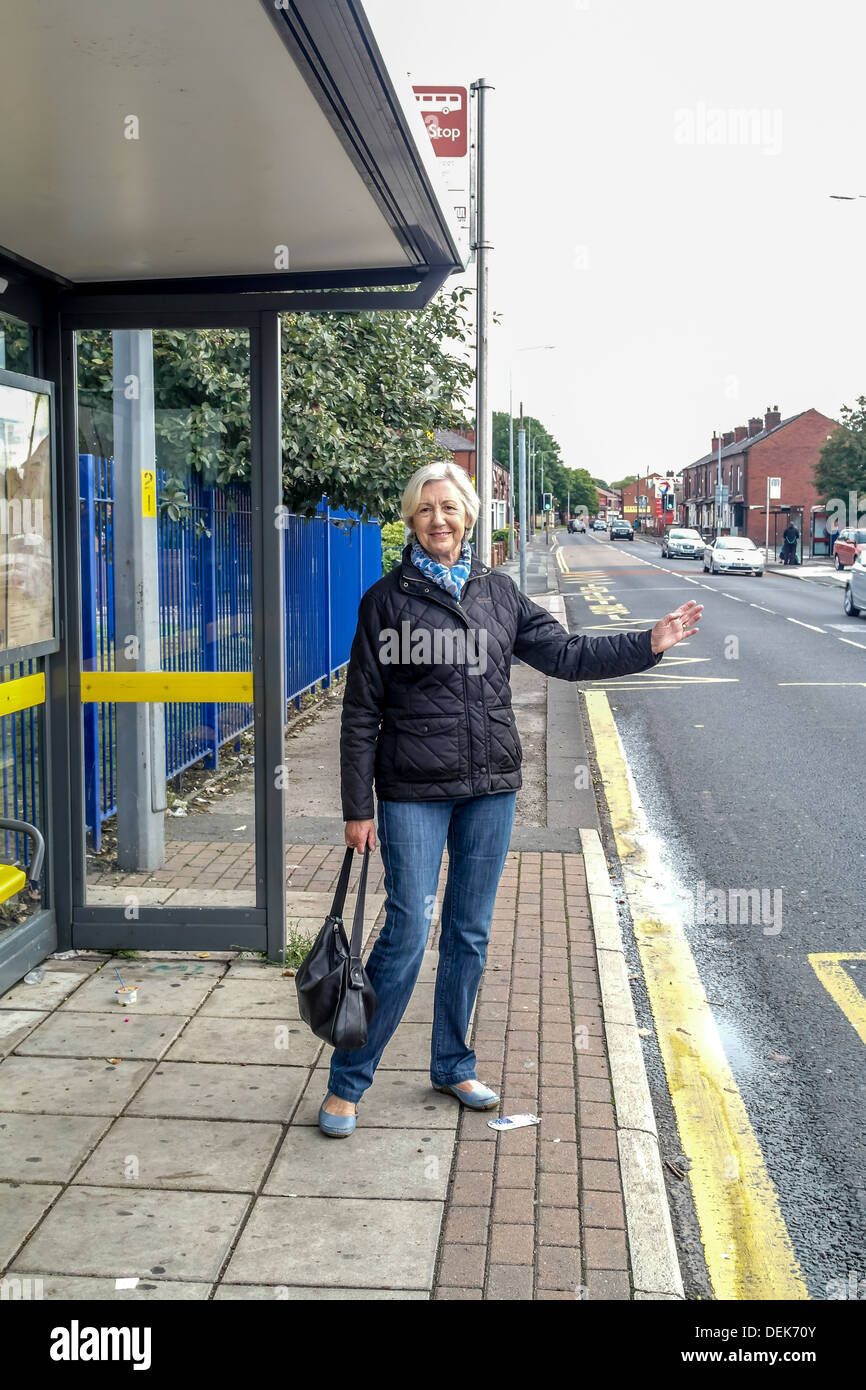 Lady Waiting for the bus with her hand outstretched Stock Photo - Alamy