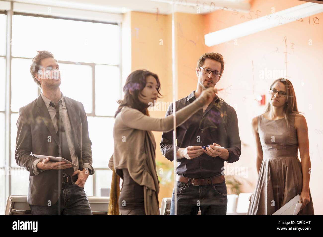 Business people writing on glass wall Stock Photo - Alamy