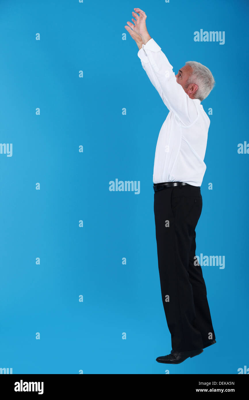 Man stretching to reach an object Stock Photo - Alamy