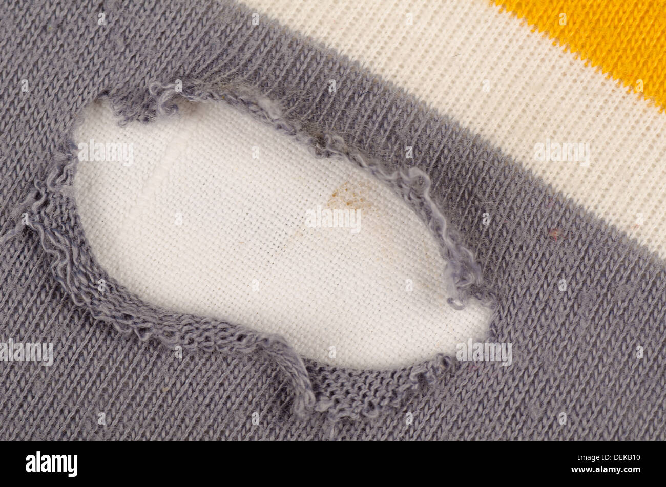 Hole in the cotton fabric of a shirt Stock Photo - Alamy