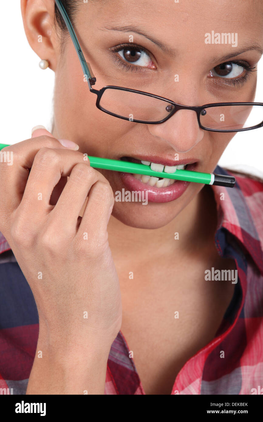 Woman biting pen Stock Photo - Alamy
