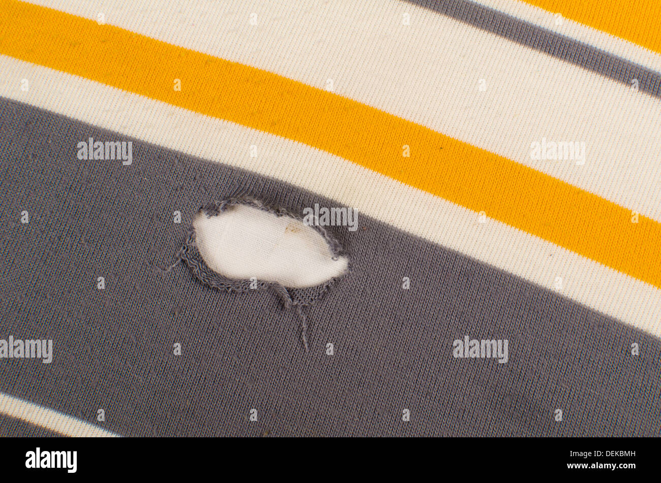 Hole in the cotton fabric of a shirt Stock Photo - Alamy