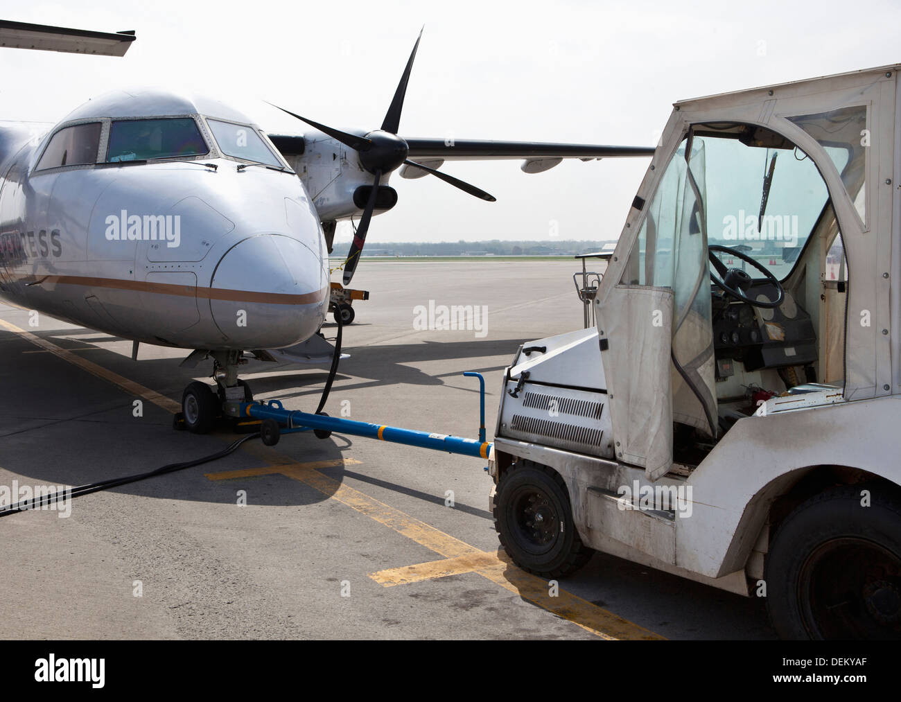 Airplane and cart parked on runway Stock Photo - Alamy