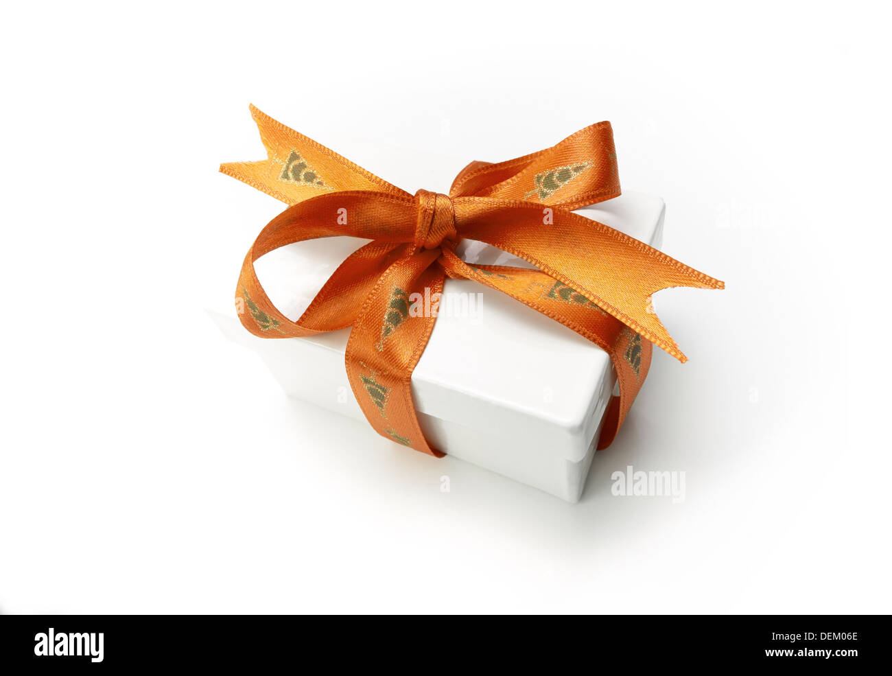 A wrapped Christmas present with a colourful gold ribbon and bow on a ...