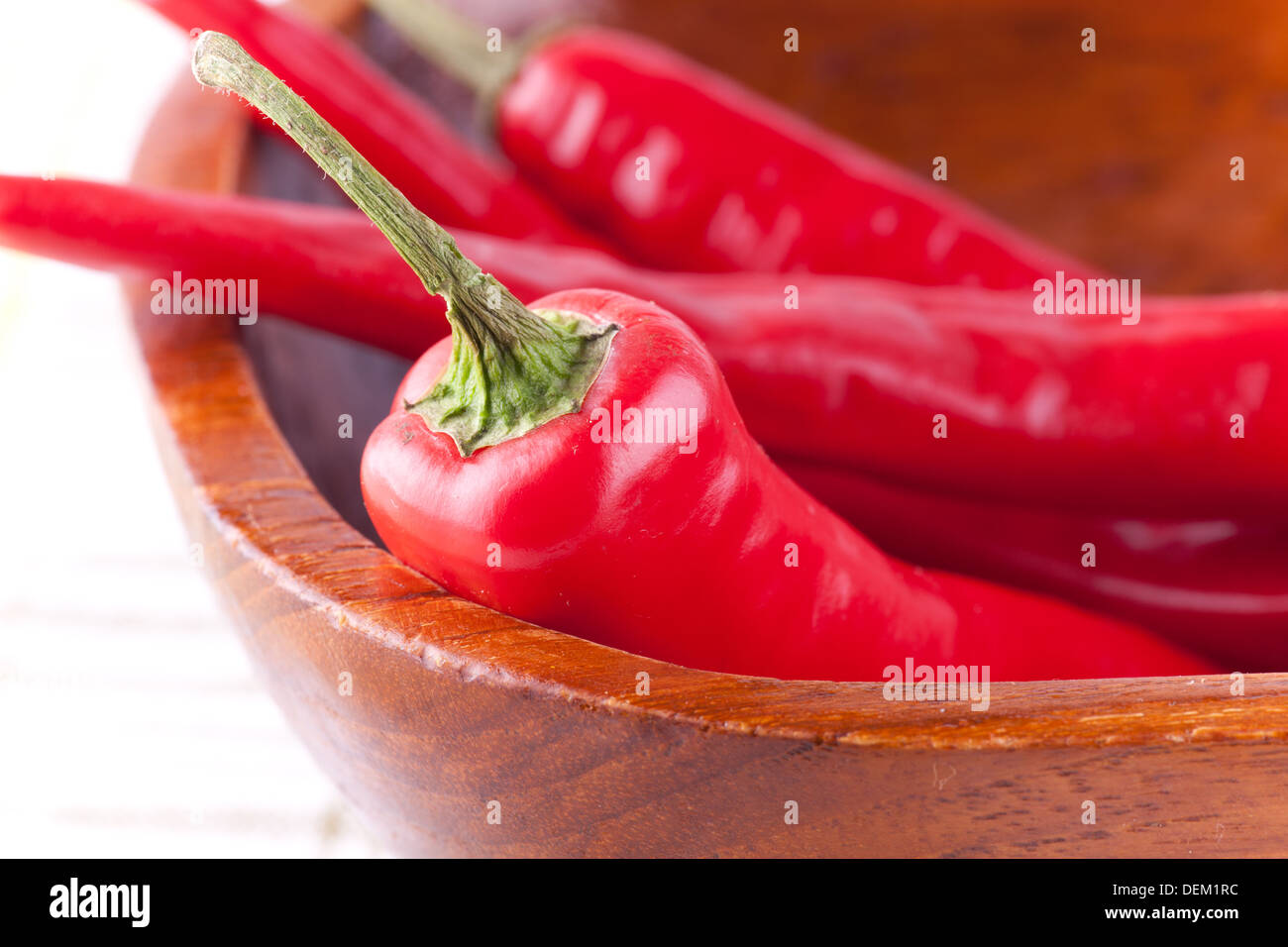 macro picture of red chili in the wooden bowl in white background Stock ...
