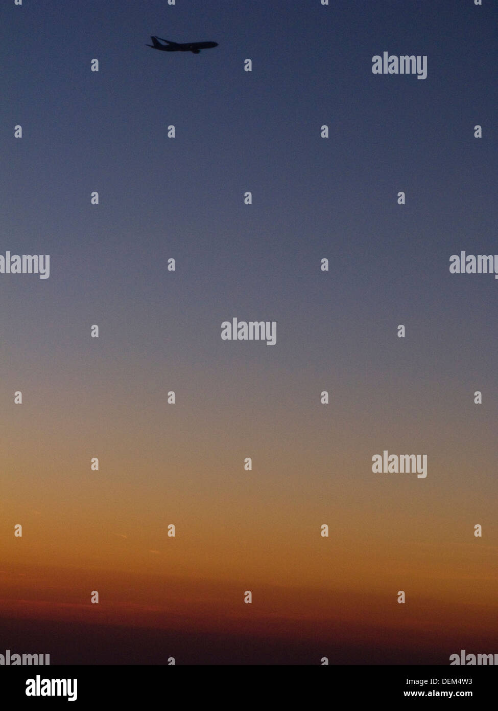 Airplane in Sky at Sunset Stock Photo - Alamy