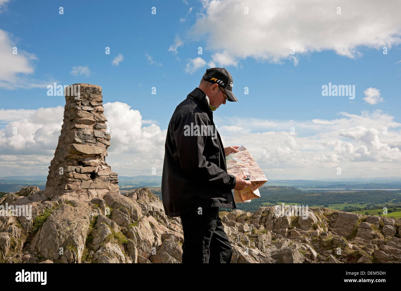 Man walker tourist holding compass and reading map of the Lake District ...