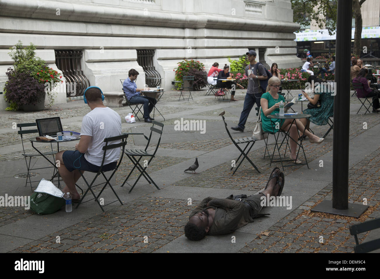 Homeless man sleeps on the pavement on the terrace at the NY Public ...