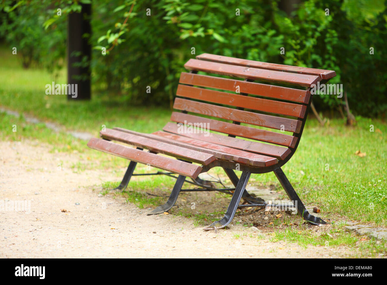 wooden park bench at a park and footpath Stock Photo - Alamy