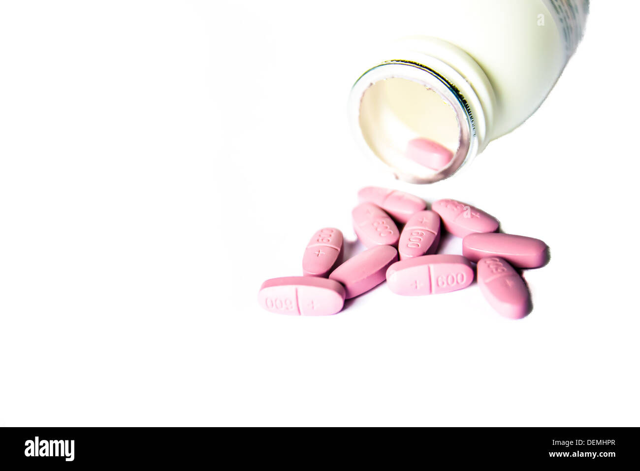 Spilled capsules from pink prescription bottle Stock Photo - Alamy