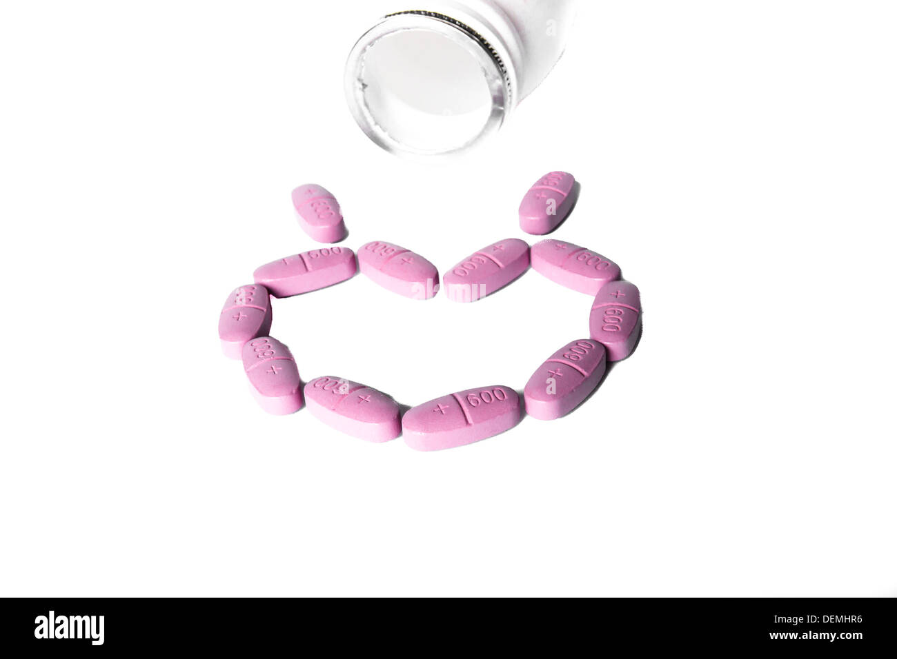 Spilled capsules from pink prescription bottle Stock Photo - Alamy